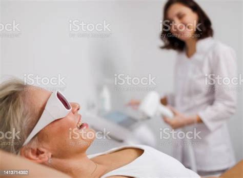 겨드랑이에 레이저 제모를하기 전에 라운지 의자에 앉아있는 백인 여성 집중력이 떨어지는 배경을 가진 여성에게 집중하십시오 2명에 대한 스톡 사진 및 기타 이미지 Istock