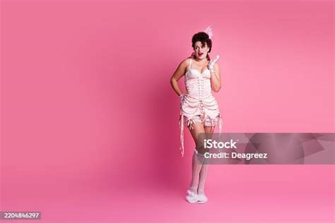 빈티지 핑크 의상을 입은 우아한 여성은 생생한 핑크색 배경에 과거와 현재를 조화시켜 바로크 양식의 우아함과 고전적인 패션을