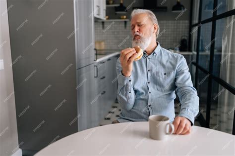 Premium Photo Portrait Of Handsome Bearded Mature Elderly Male Eating