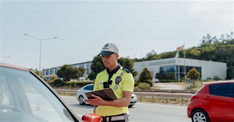클립보드를 들고 빨간 차 옆에 서 있는 남자 사진 Unsplash의 교통 경찰 이미지