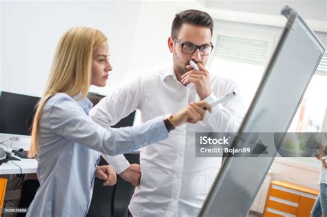 사업가 Flipboard 가리키는 표시와 함께 남성 잠겨있는 동료에 게 회사의 재정 상황을 설명 하 고 플립차트에 대한 스톡