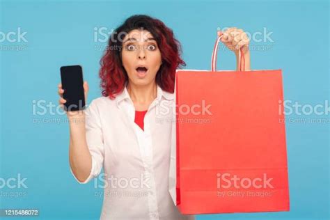 와우 멋진 쇼핑 응용 프로그램 패키지와 휴대 전화를 들고 멋진 빨간 머리와 놀란 힙스터 여자의 초상화 25 29세에 대한 스톡 사진 및 기타 이미지 Istock