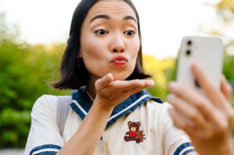 젊은 아시아 소녀 공기 키스를 불고 공원에서 스마트폰을 사용하는 동안 갈색 머리에 대한 스톡 사진 및 기타 이미지 갈색 머리 걷기 귀여운 Istock