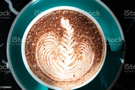 복사 공간이 있는 커피 숍에서 나무 테이블에 라 떼 아트 거품 커피 컵 커피는 가장 인기 있는 음료 중 하나입니다 에너지 레벨을