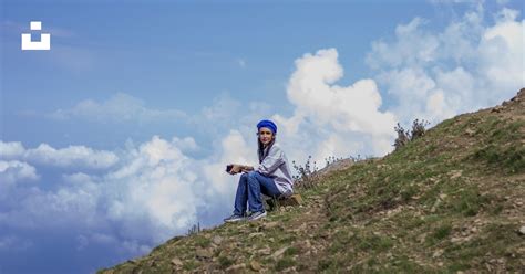 낮 동안 푸른 하늘 아래 푸른 잔디에 앉아 있는 파란 재킷을 입은 남자 사진 Unsplash의 무료 자연 이미지