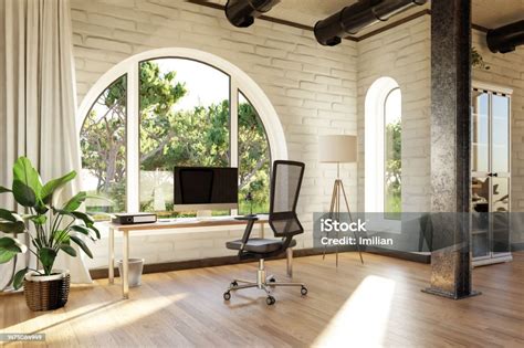 큰 아치형 창문 앞에 서있는 Pc 워크 스테이션이있는 편안한 작업장 조경보기 밝은 햇빛이 창문을 통해 빛납니다 원격 작업