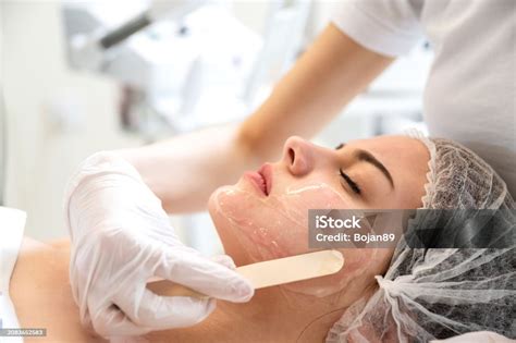 아름다운 젊은 여성의 얼굴에 화장품 젤 필링 마스크를 적용하는 나무 주걱으로 미용사 손의 근접 촬영 껍질에 대한 스톡 사진 및 기타 이미지 Istock