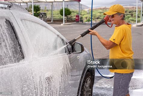 셀프 서비스 세차장에서 고압 호스로 차를 세차하는 노인 여성 Diy에 대한 스톡 사진 및 기타 이미지 Diy 건조한 경제