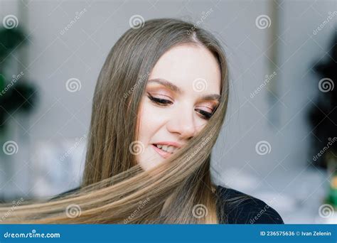 Girl Touching Her Hair And Smiling While Posing At Interior Looking In