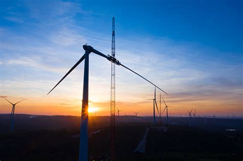 큰 빨간색 크레인을 사용하는 풍력 터빈의 조립 된 로터 블레이드는 공중보기로 높은 곳에서 볼 수 있습니다 지속 가능한 성장을위한