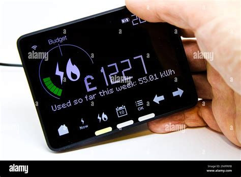 Hand Holding A Smart Meter Monitor Showing Current Week Energy Usage