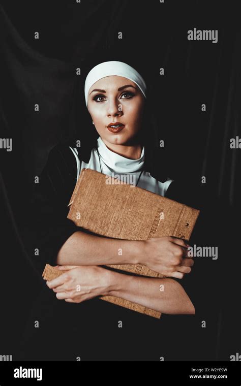 Beautiful Young Nun In Religion Black Suit Holds Bible And Posing On
