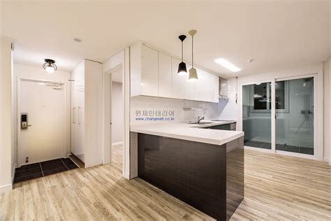 32평 아파트의 일자형 주방을 아일랜드 식탁 겸 조리대를 추가해서 실용적인 ㄱ주방으로 만들었습니다 투톤의 식탁 등과 백색의 조각 타일 투톤의 싱크대의 조화가 심플한