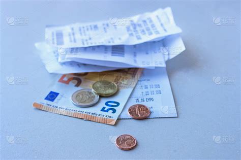硬币和钞票躺在几张收据上有选择性的重点概念金融