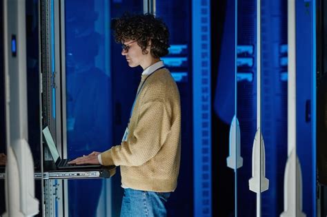 Premium Photo Technician Using Laptop In Large Data Center