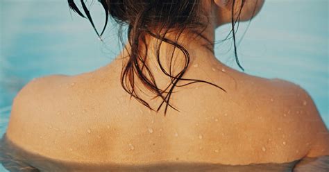 수영장에서 휴식을 취하는 아름다운 젊은 여성 물방울이 있는 어깨가 닫힙니다 거위 덩어리와 젖은 피부를 가진 갈색 머리 소녀의 뒷모습 여름 방학 여름 휴가 즐기기