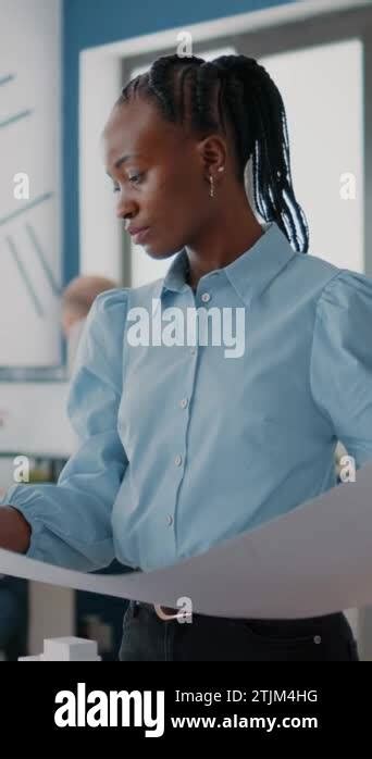Vertical Video Woman Architect Analyzing Building Model And Blueprints Plans For Project