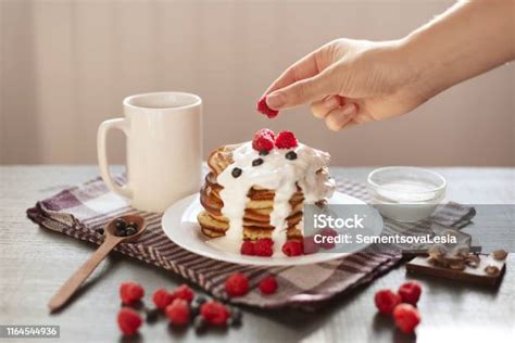 블루베리와 딸기설탕 팬케이크를 장식하는 페소 접시와 딸기 숟가락 차 또는 커피 한 잔을 수건에 회수 한 테이블 제품에 주부 요리 맛있는 Breafast 건강한 식생활에 대한