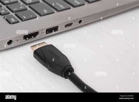 Man Is Connecting Black Hdmi Cable Into Hdmi Port Of The Modern Laptop On White Background Stock