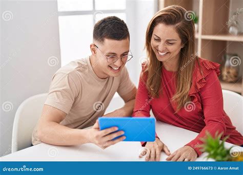 Madre E Hijo Hombres Y Mujeres Usando Un Touchpad Sentado En La Mesa En Casa Imagen De Archivo