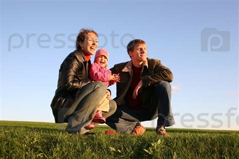 Фотография на тему Семья из трех человек смотрит на закат Pressfoto